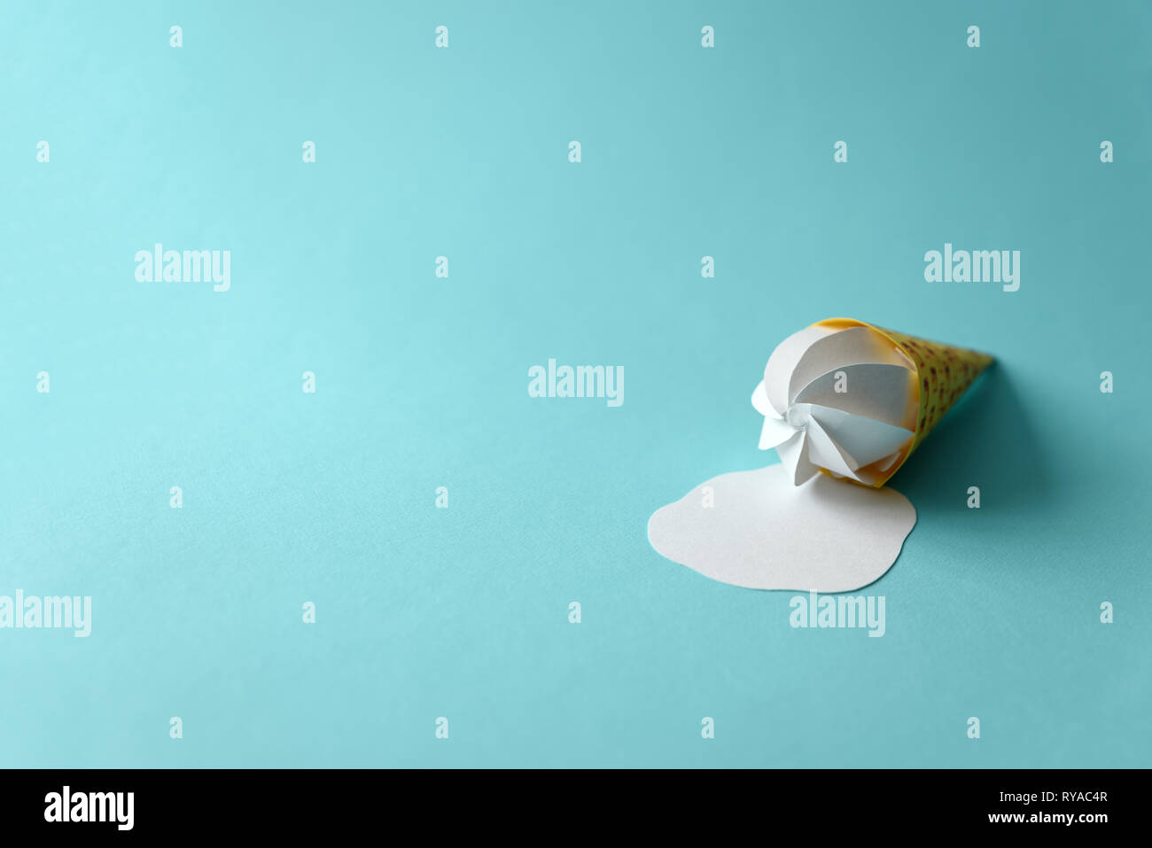 Melted paper vanila ice-cream cone on blue background. Copy space ...