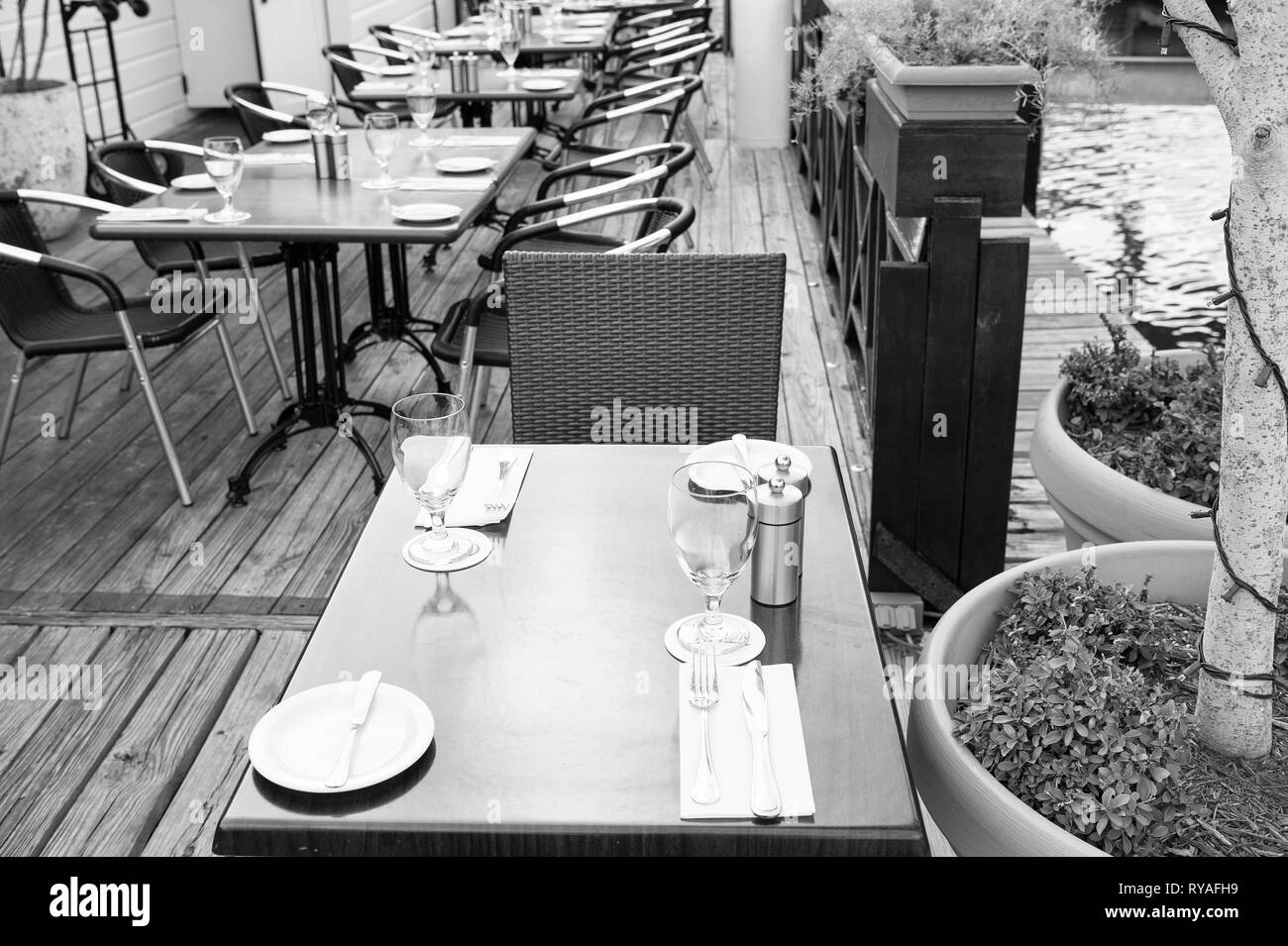 Open air restaurant or cafe with tables served with plates glasses and ...