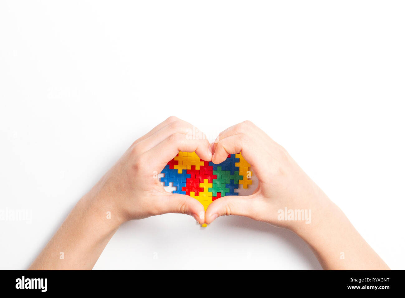 Kid hands in the shape of heart and colorful heart made of plastic ...