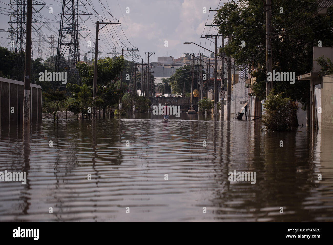 Sao Paulo, Brazil. 12th Mar, 2019. A man wading through a flooded ...