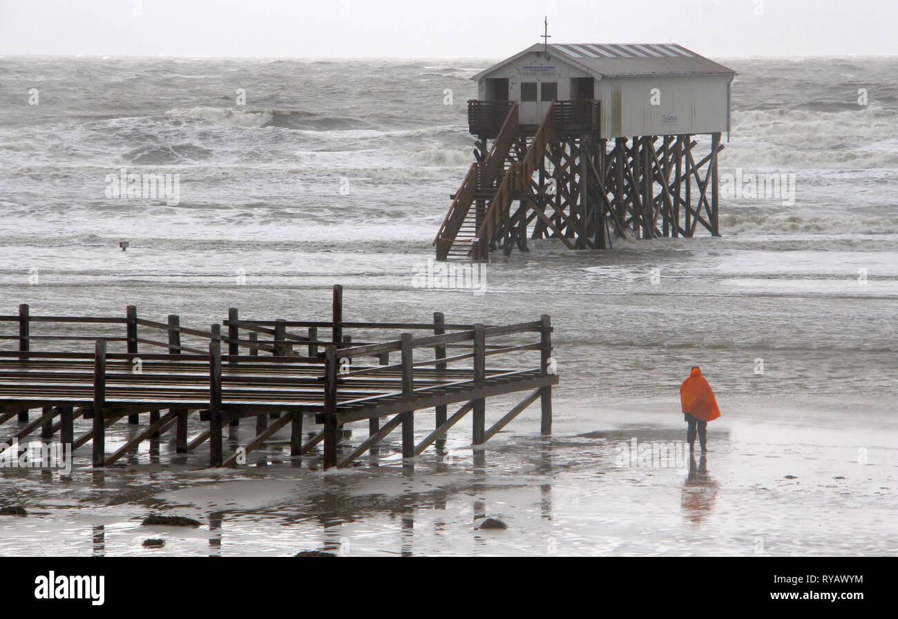 St. Peter Ording, Germany. 13th Mar, 2019. A walker stands at the beach ...