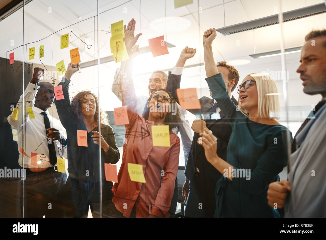 Ecstatic group of diverse businesspeople cheering and celebrating ...