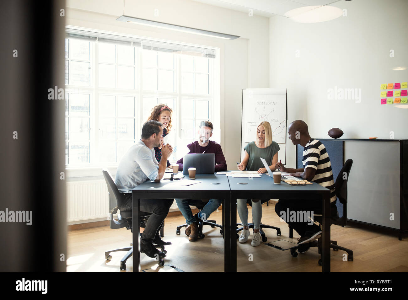 Diverse group of young designers talking together during a meeting ...