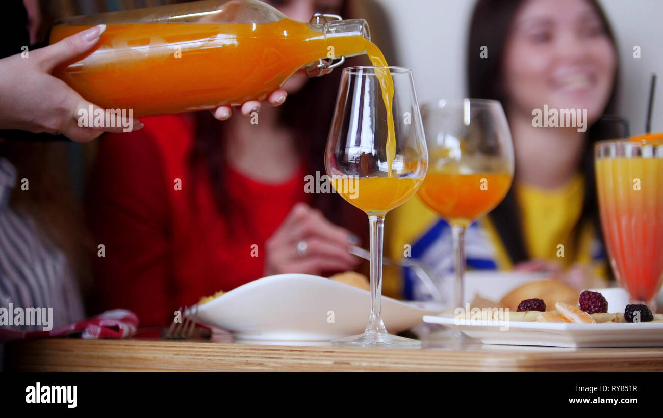 A person pouring a juice from the bottle in the glass Stock Photo - Alamy