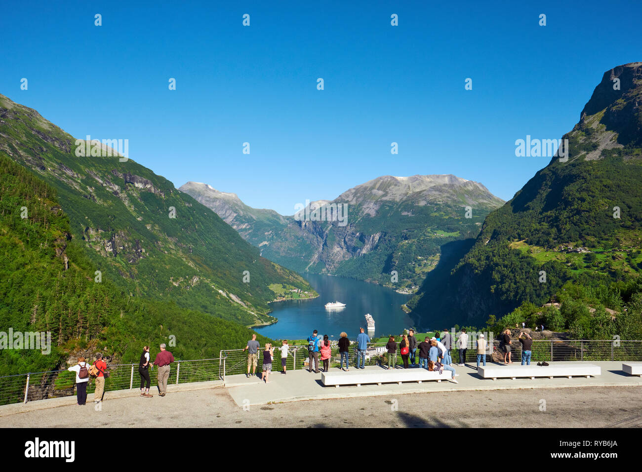 Tourists looking out over Geirangerfjord from Flydalsjuvet viewpoint in ...