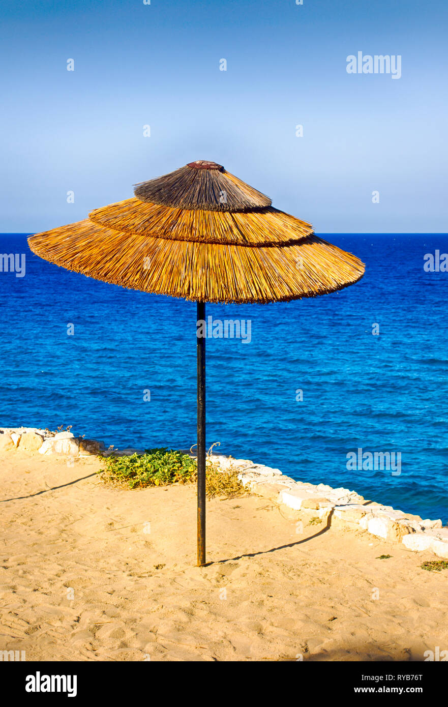 Straw beach umbrella on the sea beach Stock Photo - Alamy