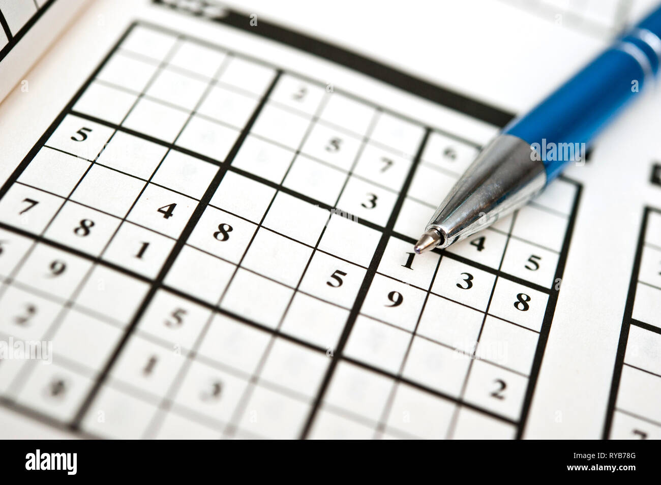 blue pen and a book with Sudoku puzzles to solve Stock Photo - Alamy