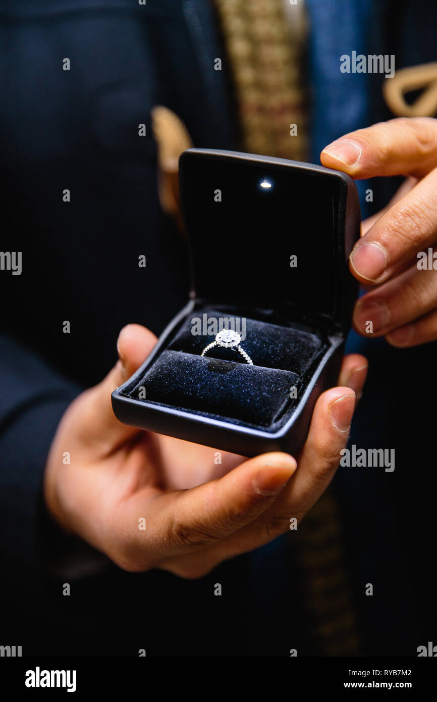 Real life proposal: Man holds an illuminated engagement ring - Blue ...