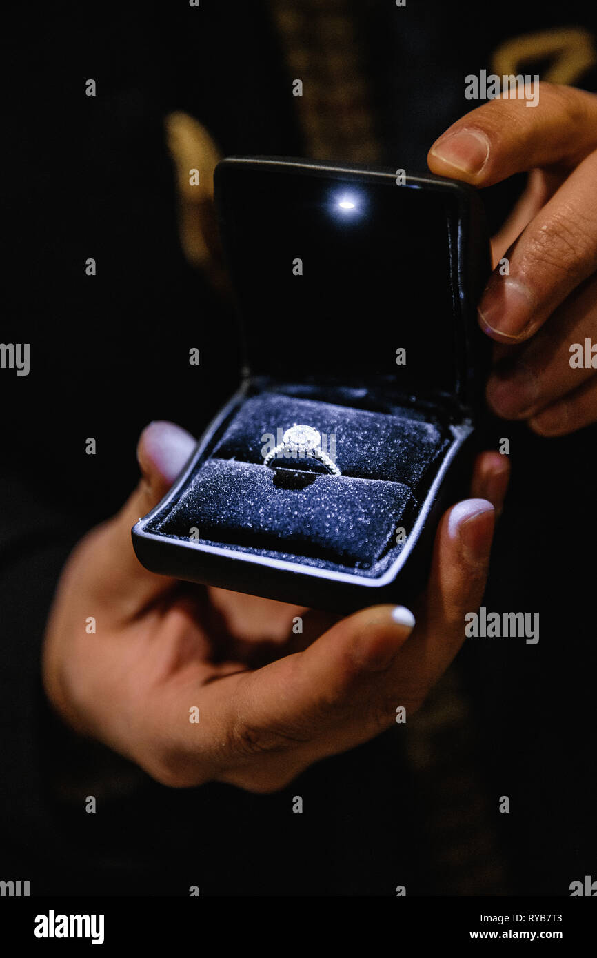 Real life proposal: Man holds an illuminated engagement ring - Blue ...
