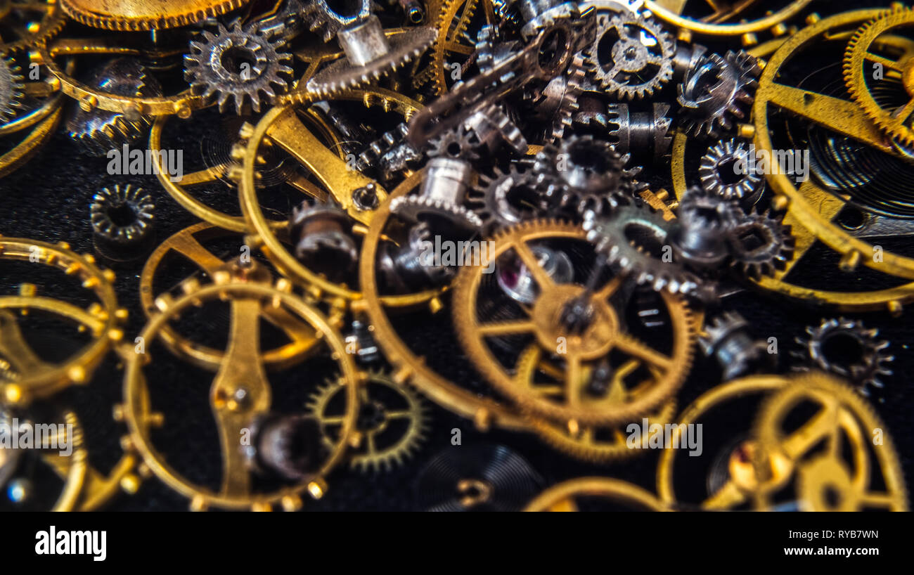 precision engineered toothed brass metal cog wheels on black background ...