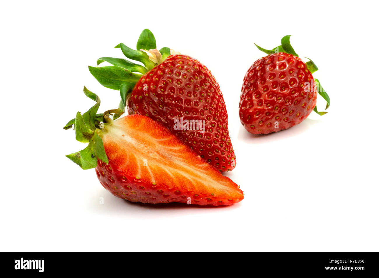 Two whole strawberry fruits and half isolated on white background Stock ...