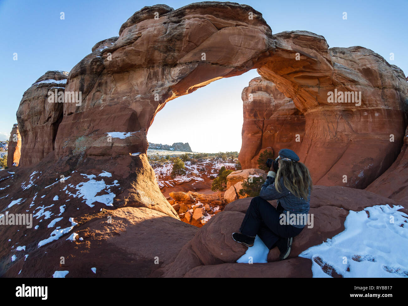 Woman photographing Broken Arch with a bit of snow early December Stock ...