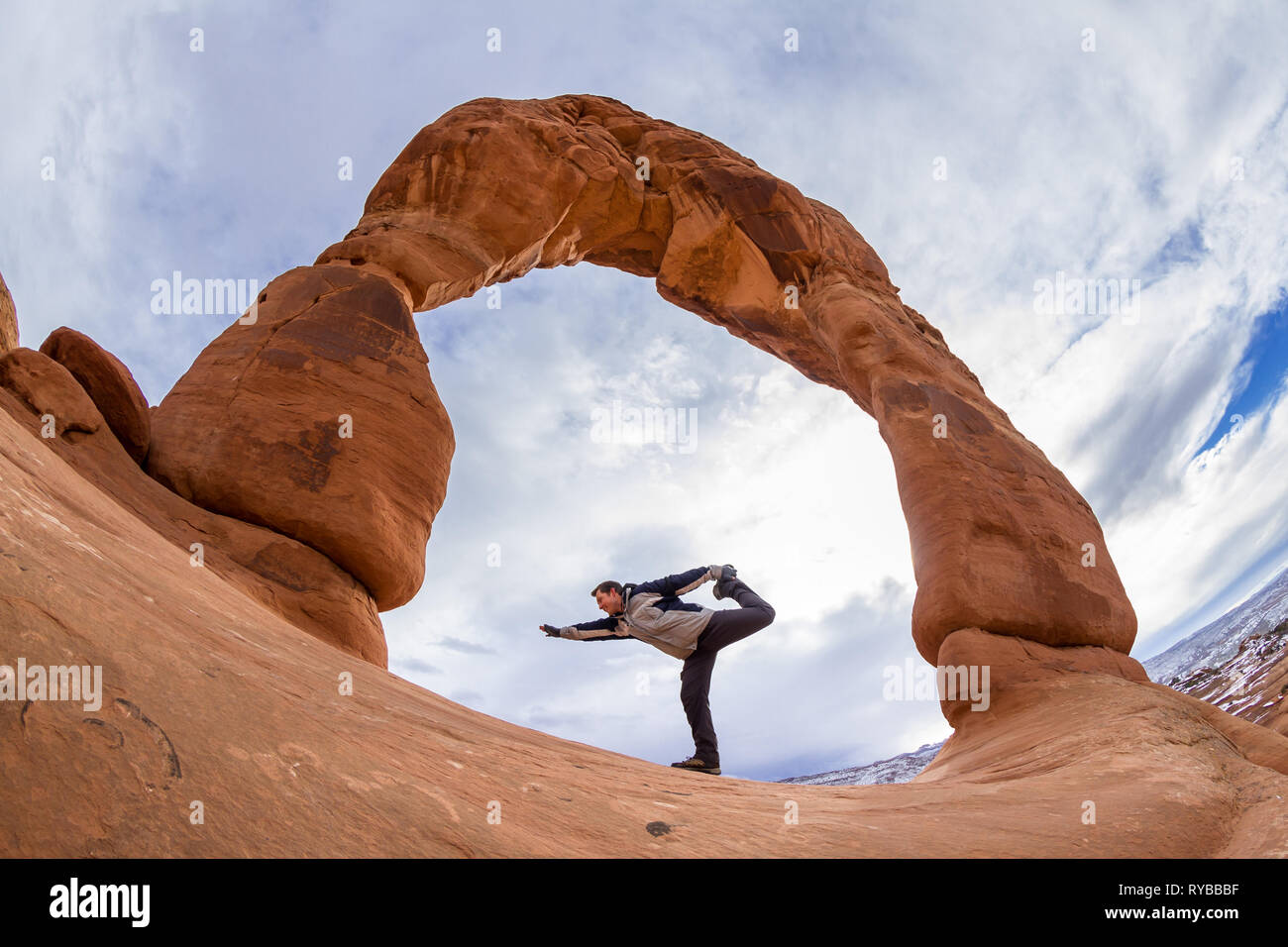 man unsuccessfully trying to do a balancing pose at the base of ...