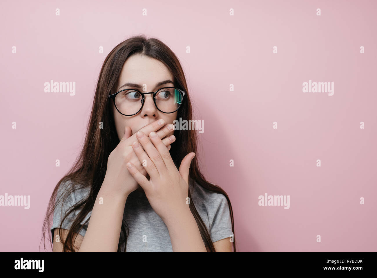 Stunned Crazy Girl Stares With Scared Expression Covers Mouth With Both Hands Wears Gray T