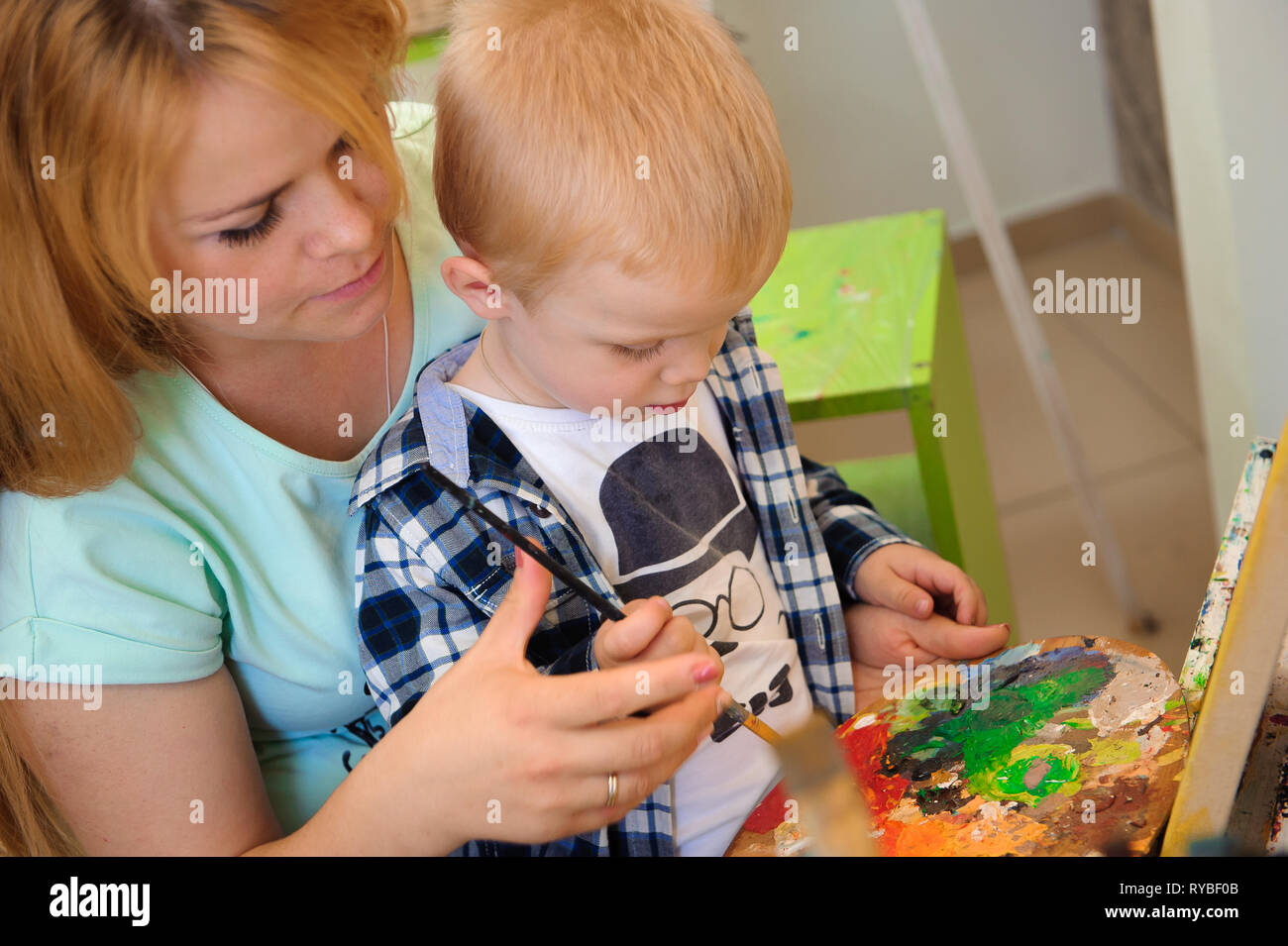Mother and child draw a picture paints, art lesson Stock Photo - Alamy