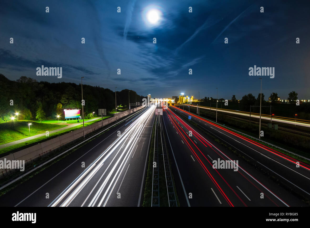 Highway traffic motion light trails at night under moonlight. Long ...