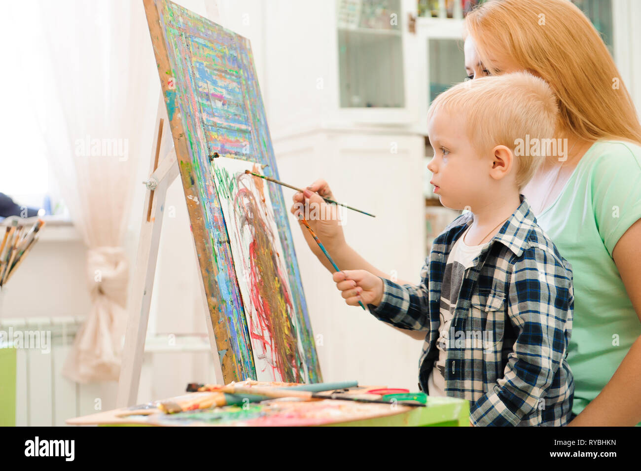 Mother and child draw a picture paints, art lesson Stock Photo - Alamy