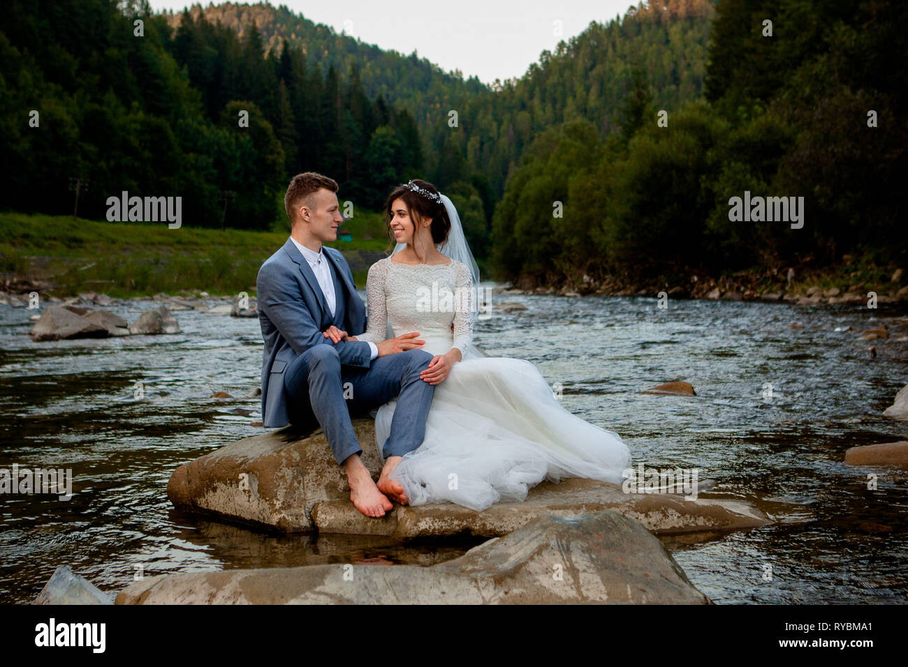 Happy newlyweds standing and smiling on the river . Honeymooners, photo ...