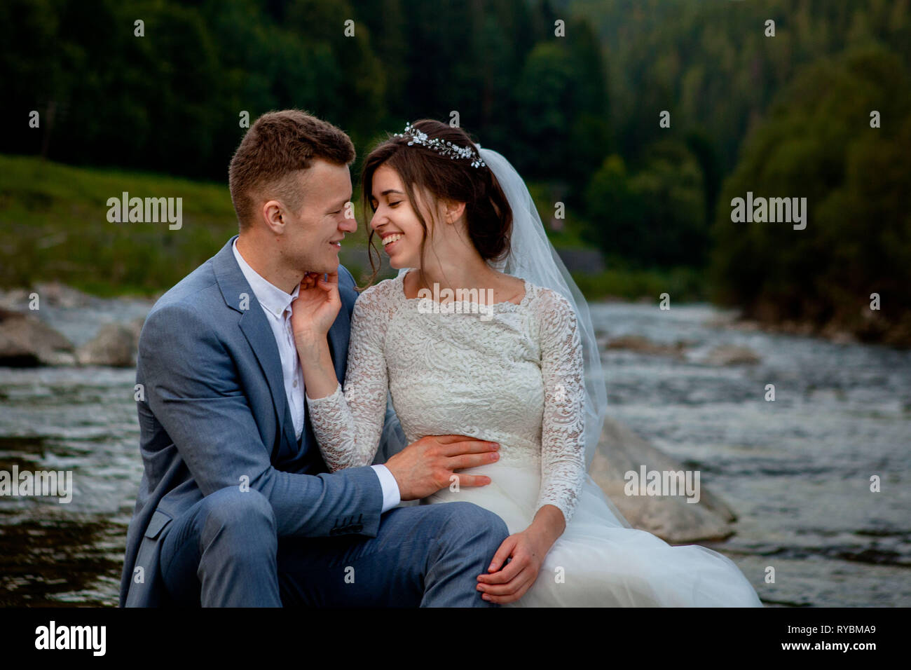 Happy newlyweds standing and smiling on the river . Honeymooners, photo ...