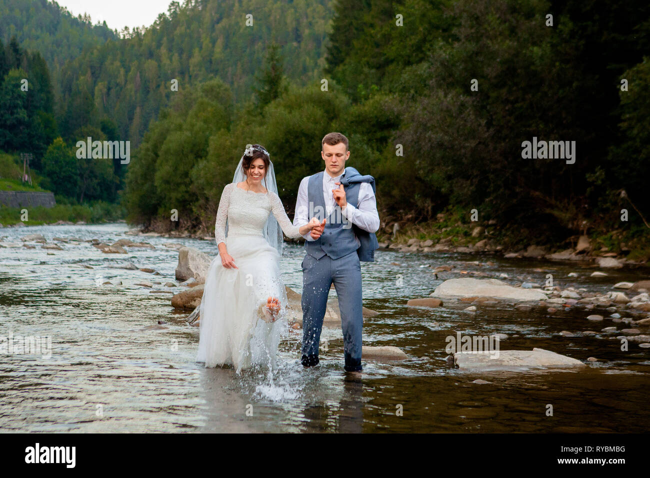 Happy newlyweds standing and smiling on the river . Honeymooners, photo ...