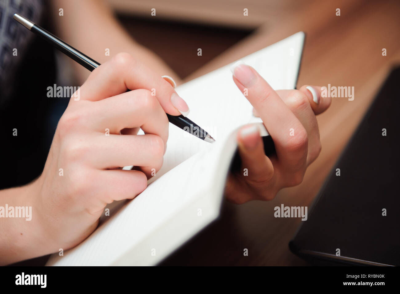 Closeup of a female hand writing on an blank notebook with a pen Stock ...