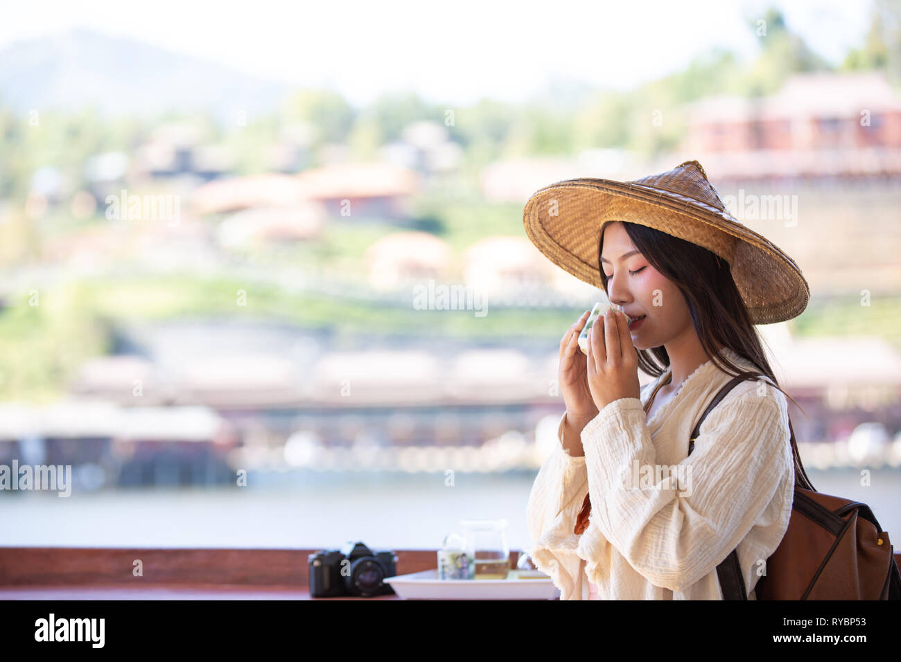 Female tourists are sitting and sipping tea by the reservoir and ...