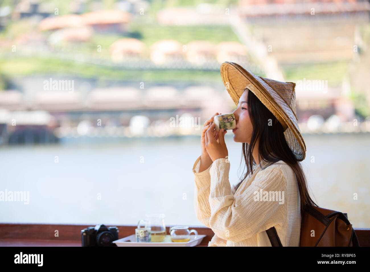 Female tourists are sitting and sipping tea by the reservoir and ...