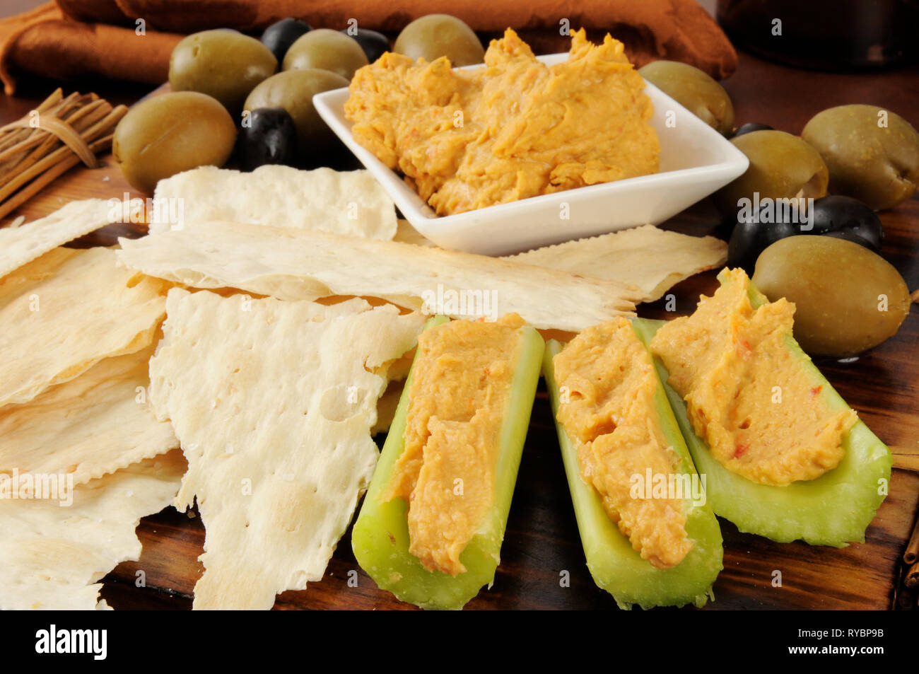 Three pepper hummus with green and black olives and sesame crisps Stock ...