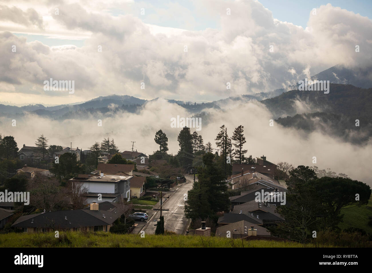 Dramatic clouds rise over sleepy suburban neighborhood in hills at ...