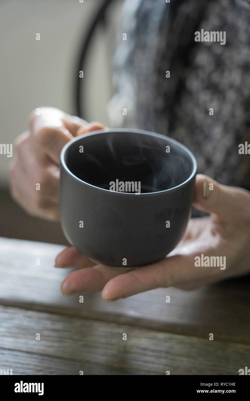 middle aged woman holds a tea cup Stock Photo - Alamy