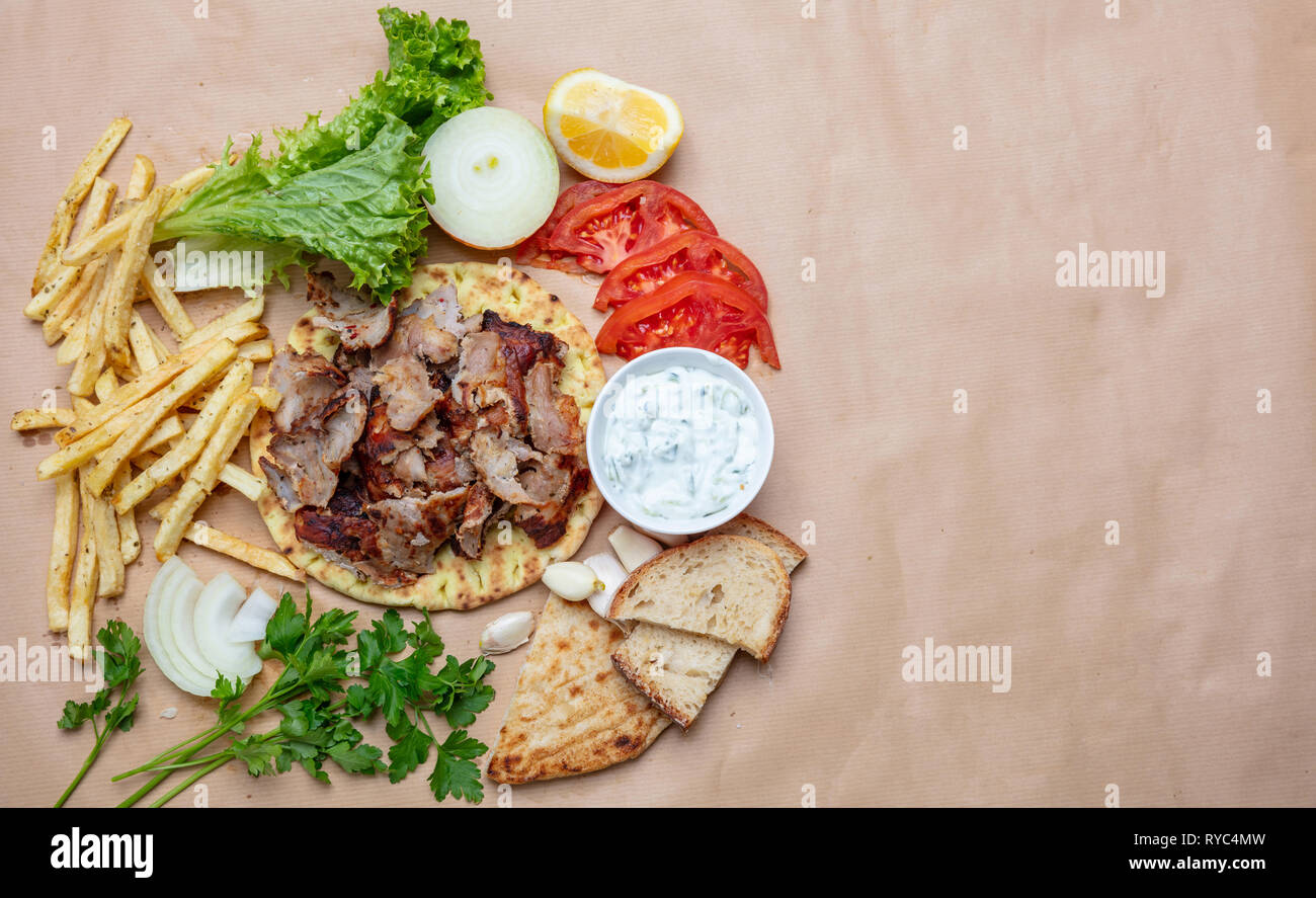 Shawarma, gyros on pita bread, vegetables and tzatziki sauce, top view ...