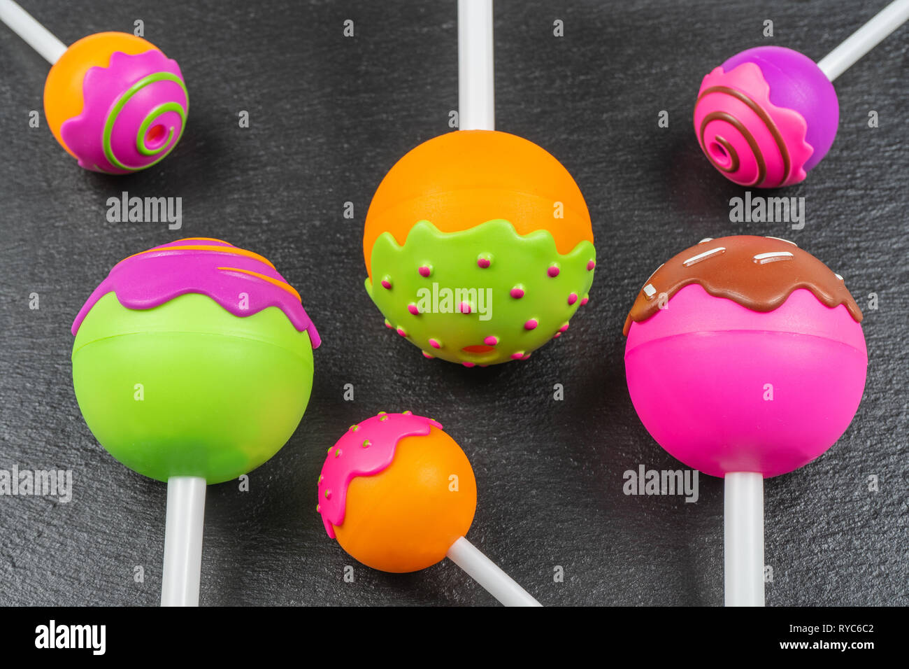 Colorful plastic candies and lollipops over stone background Stock ...