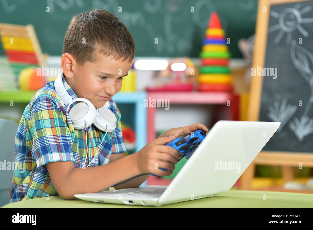 Portrait of emotional boy playing computer game with laptop Stock Photo ...