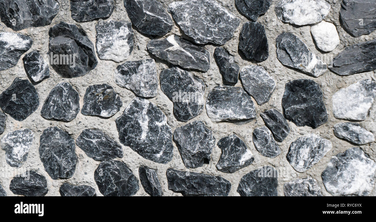 horizontal detail of a rock wall background made of small jagged ...