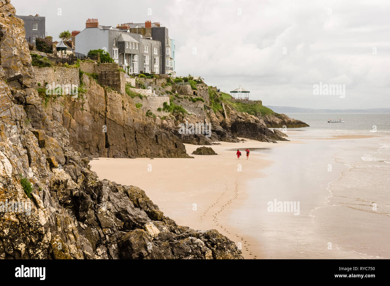 A view of Tenby South Beach with cliffs, sand, tide and two distant ...