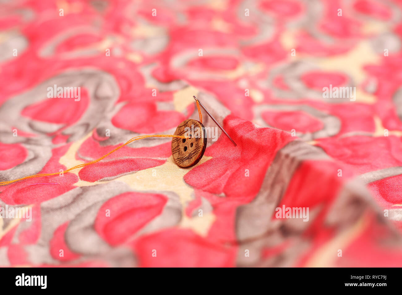 Picture of button and needle in the attached thread. Isolated on the ...