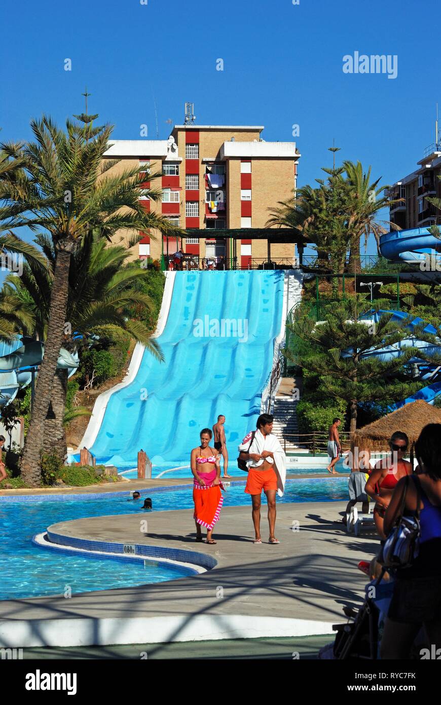 Water slide and pool in the water park with tourists enjoying the ...