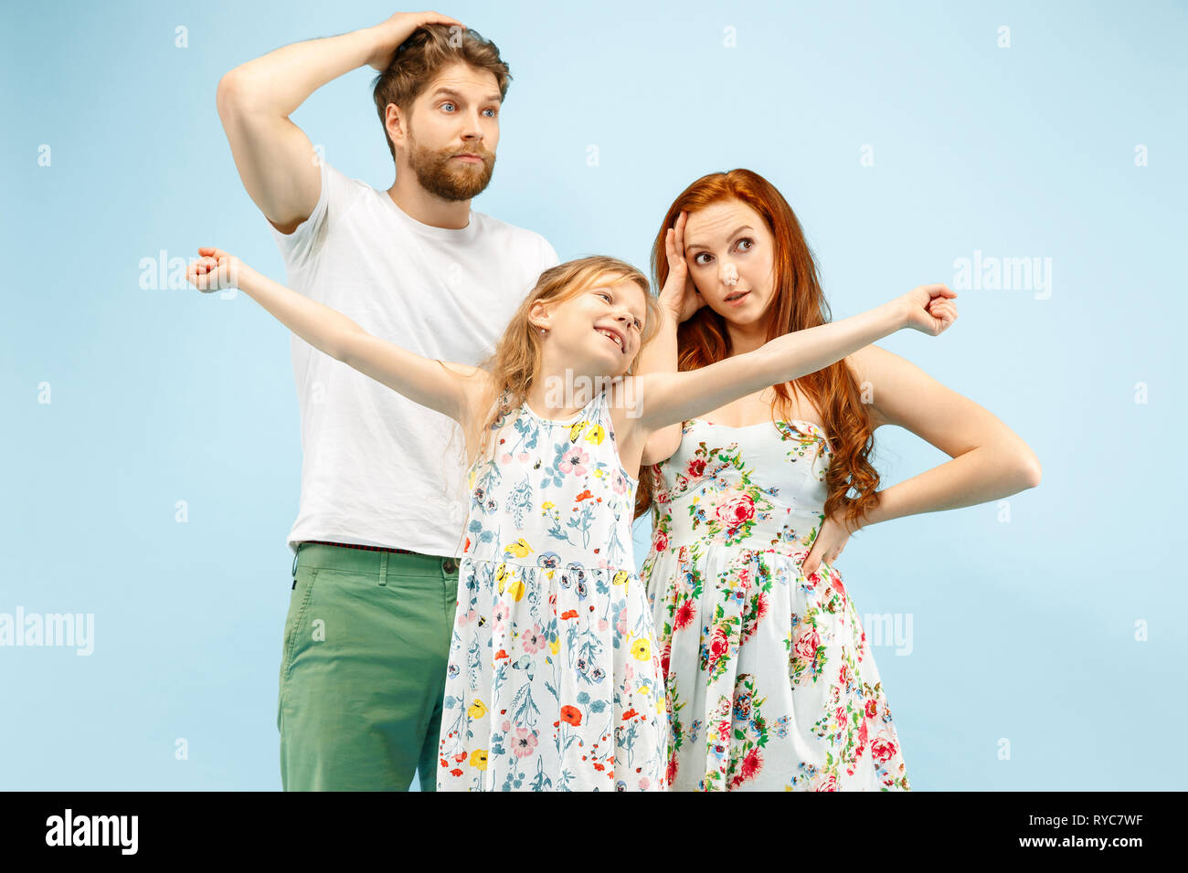 Happy surprised parent with daughter at studio isolated on blue ...