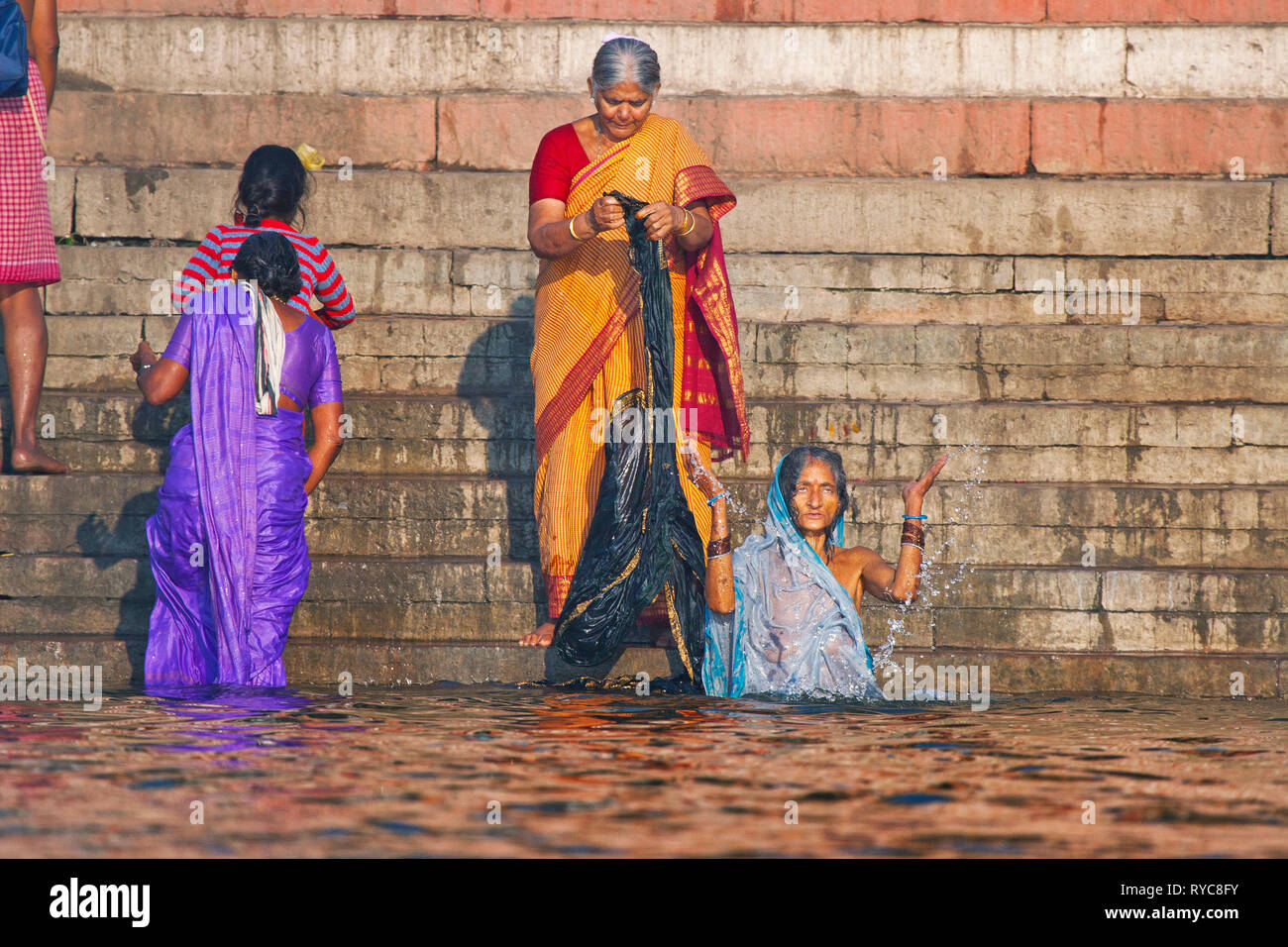 Women praying and washing in the river Ganges in Varanasi in India ...