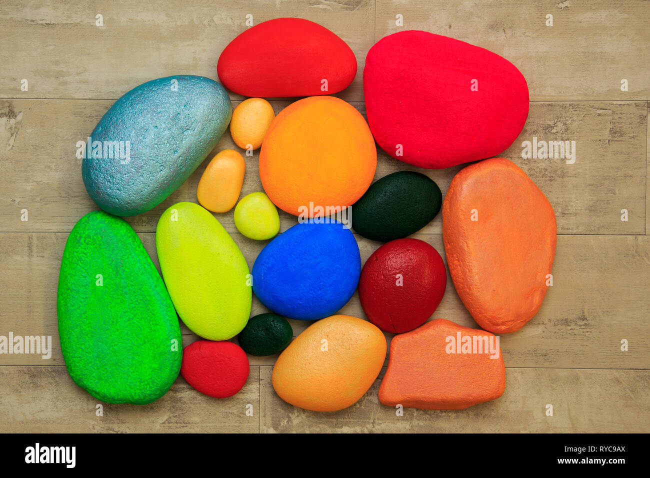 Colourful painted stones on a shabby board background Stock Photo - Alamy