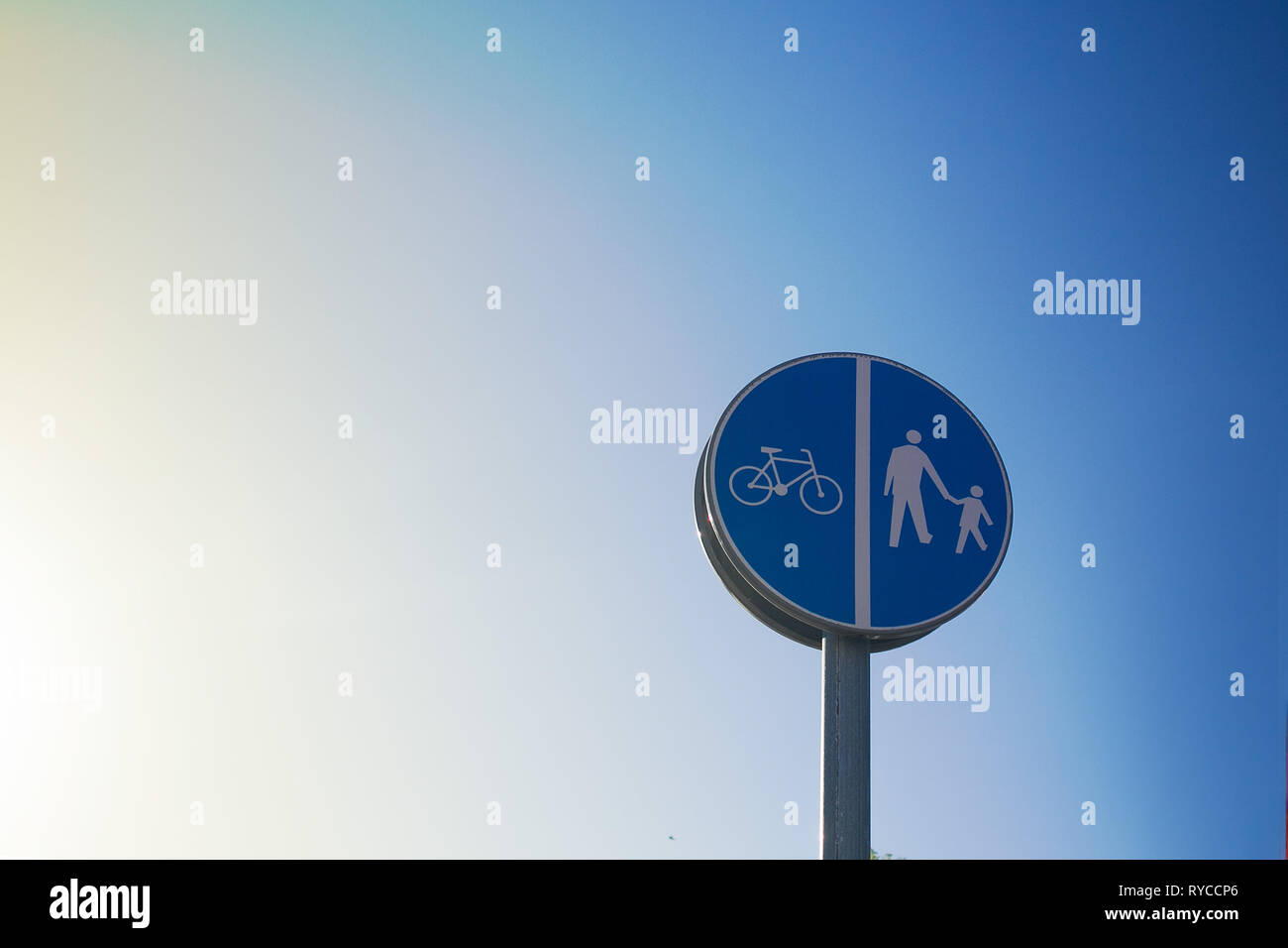 Road sign informing about cycle path and footpath ahead with a blue sky ...