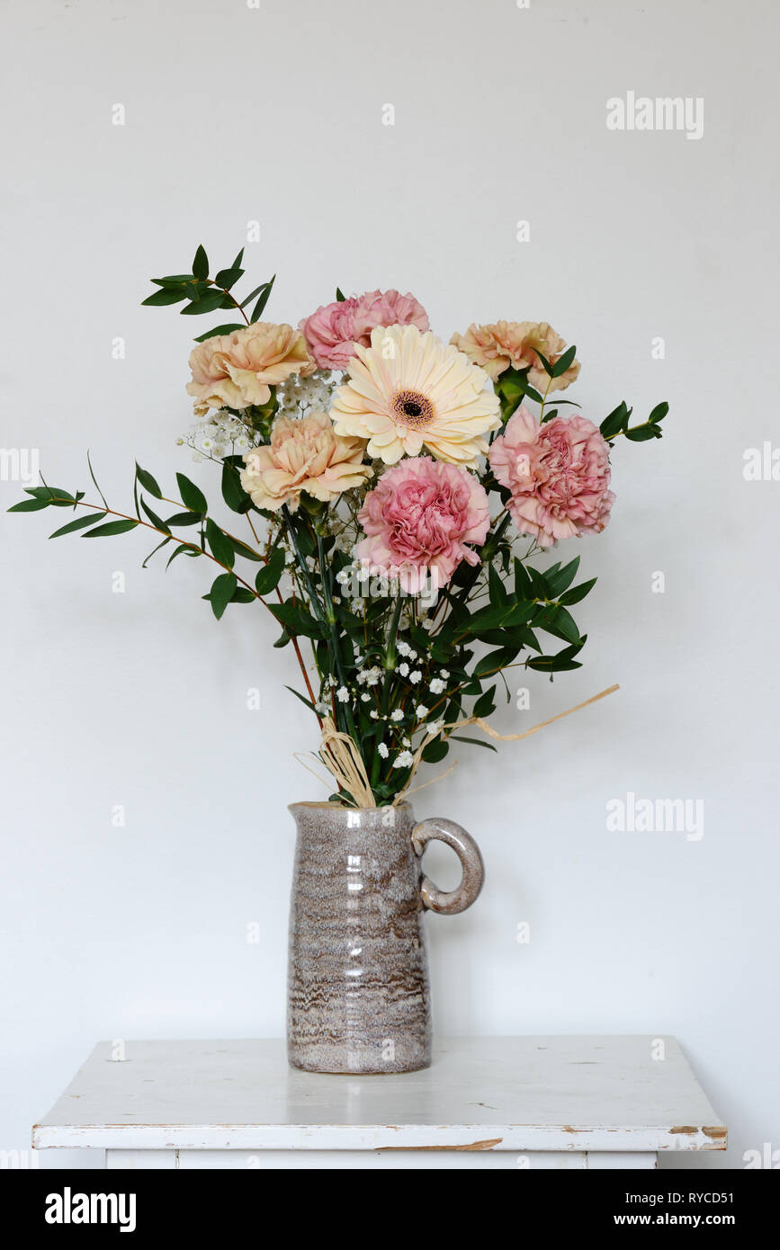 beautiful bouquet of carnations and gerberas in a ceramic vase on a ...
