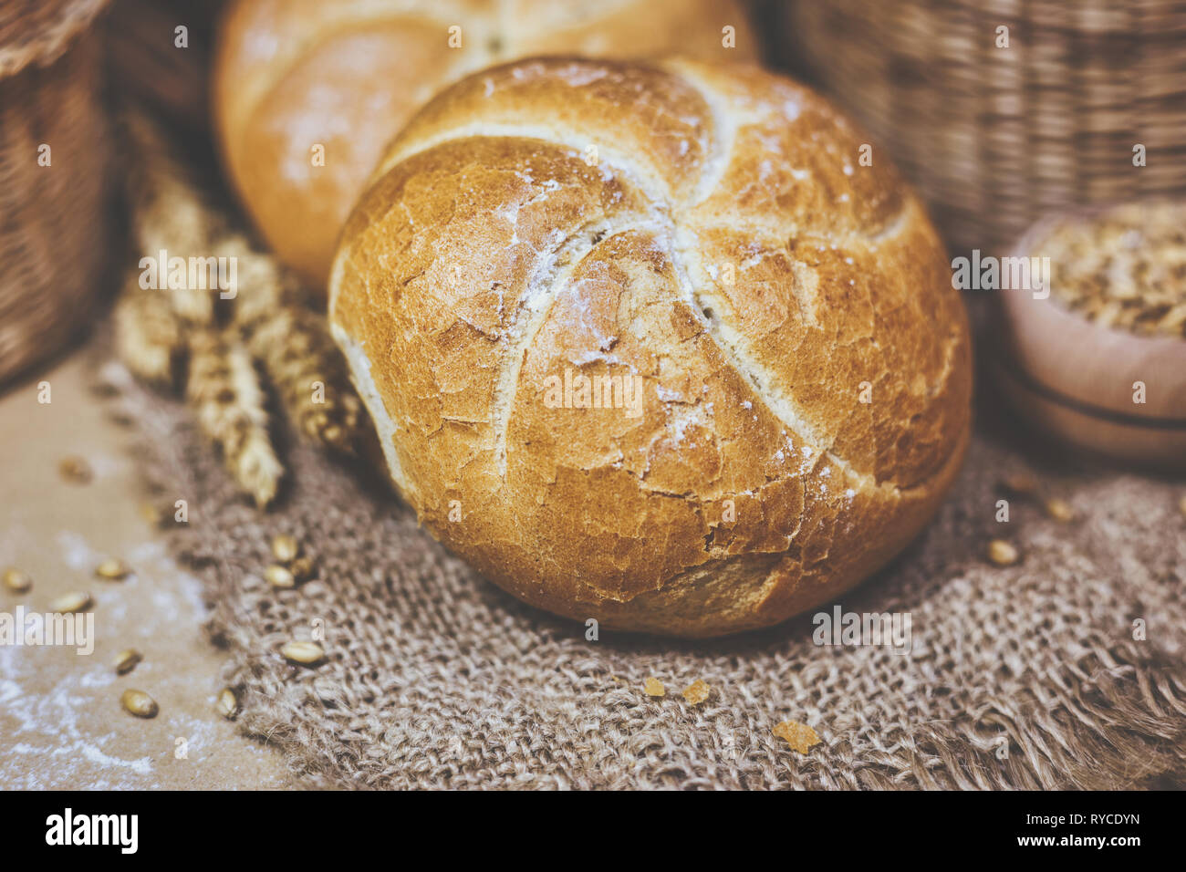 Close-up view of freshly baked bread on a rustic background with wheat ...