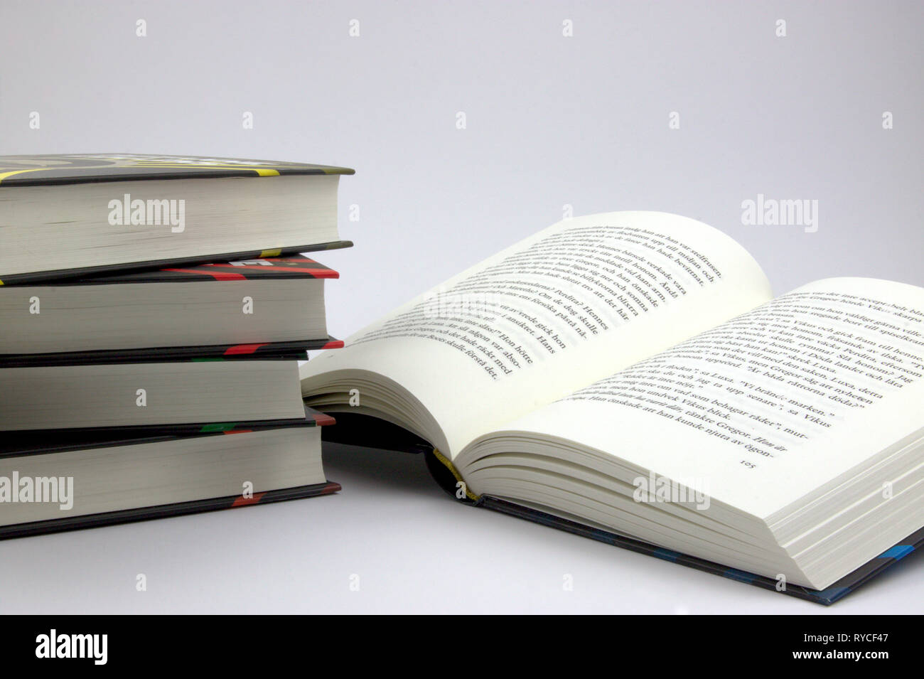 Photo of pile of books as well as an open book, taken in a studio Stock ...