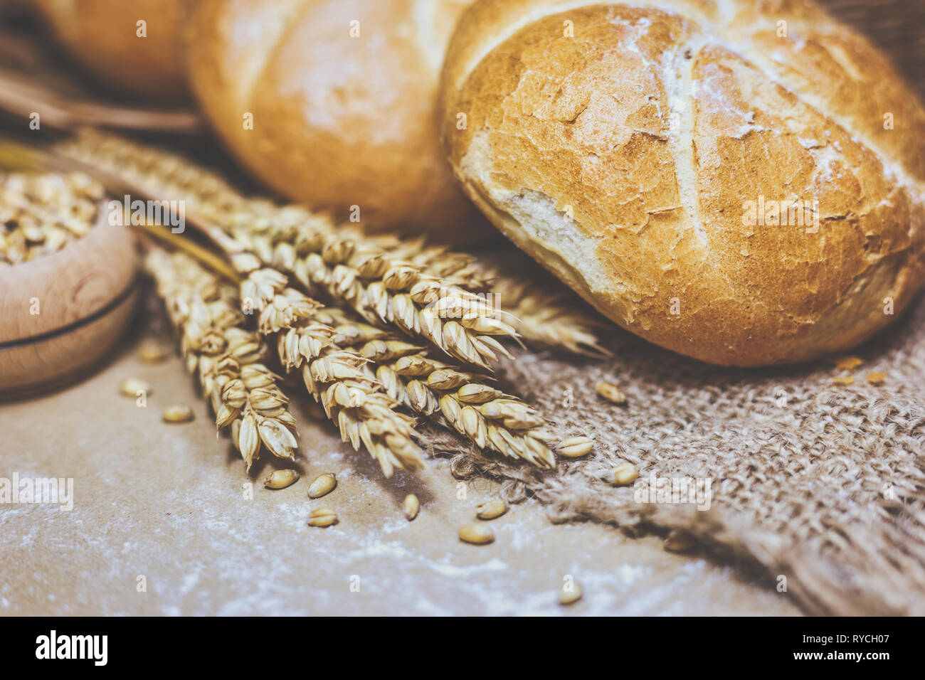 Close-up view of freshly baked bread on a rustic background with wheat ...