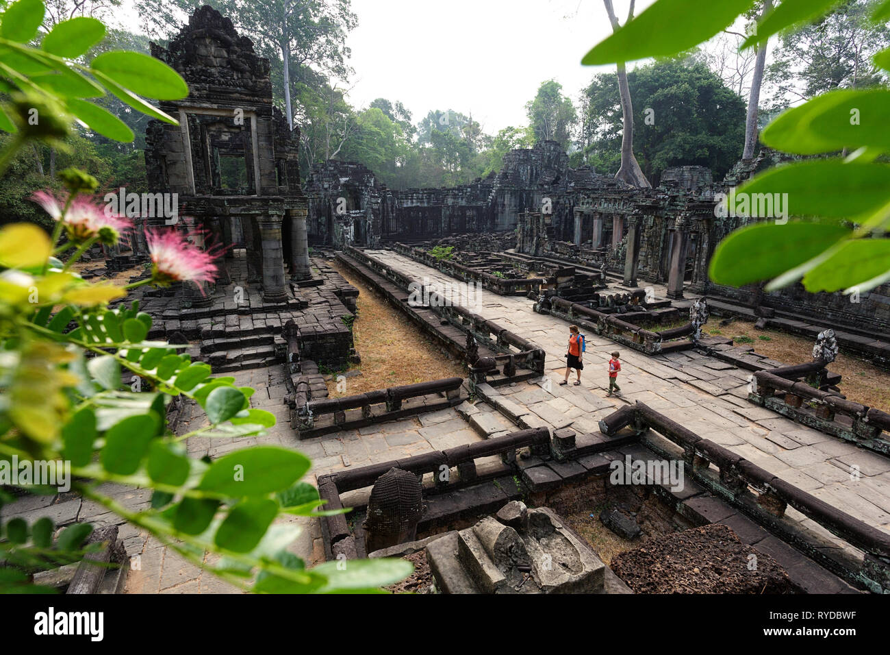 Woman and child walking in the ancient and majestic temple of Preah ...