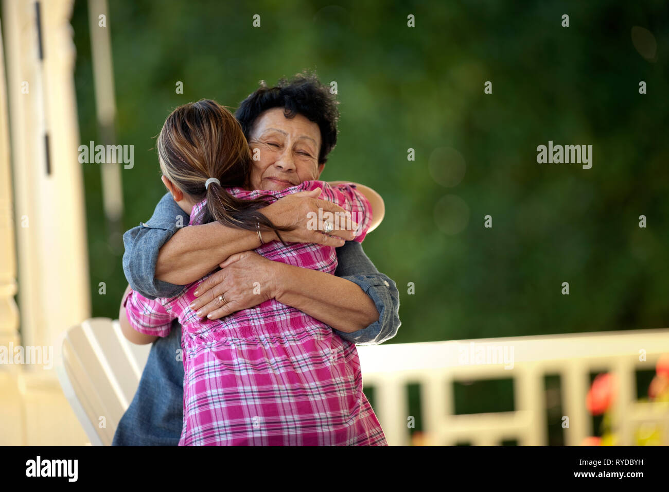 Senior woman receiving a hug from her granddaughter Stock Photo - Alamy