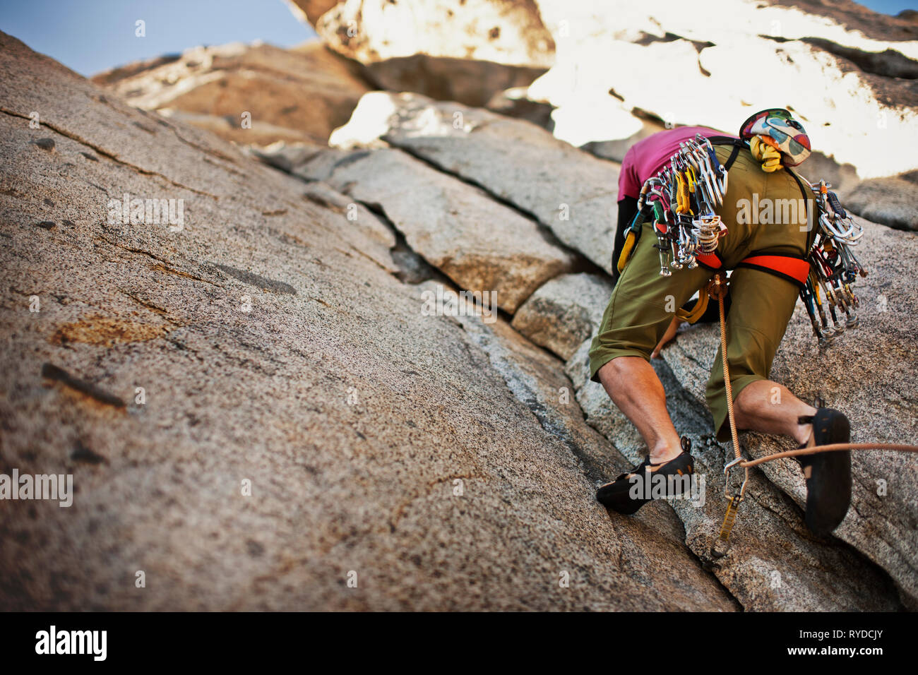 Low-angle view of rock climber climbing on mountain top Stock Photo - Alamy
