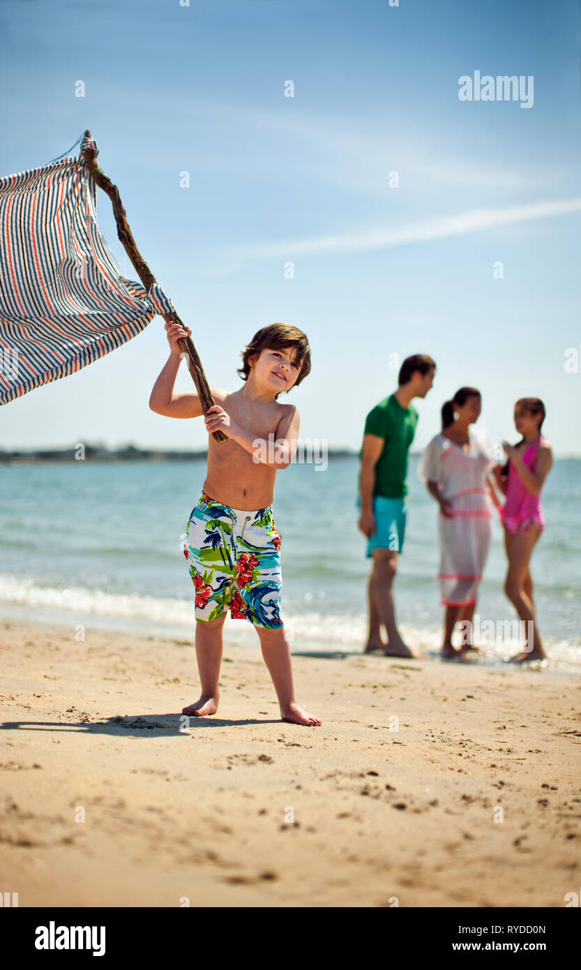 Young boy waves flag at beach Stock Photo - Alamy