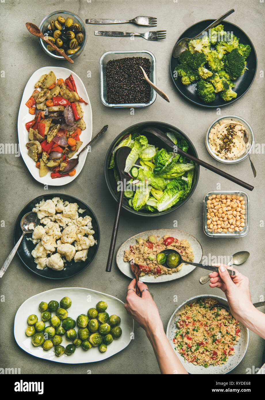 Vegan dinner table setting. Healthy dishes in plates on concrete table ...